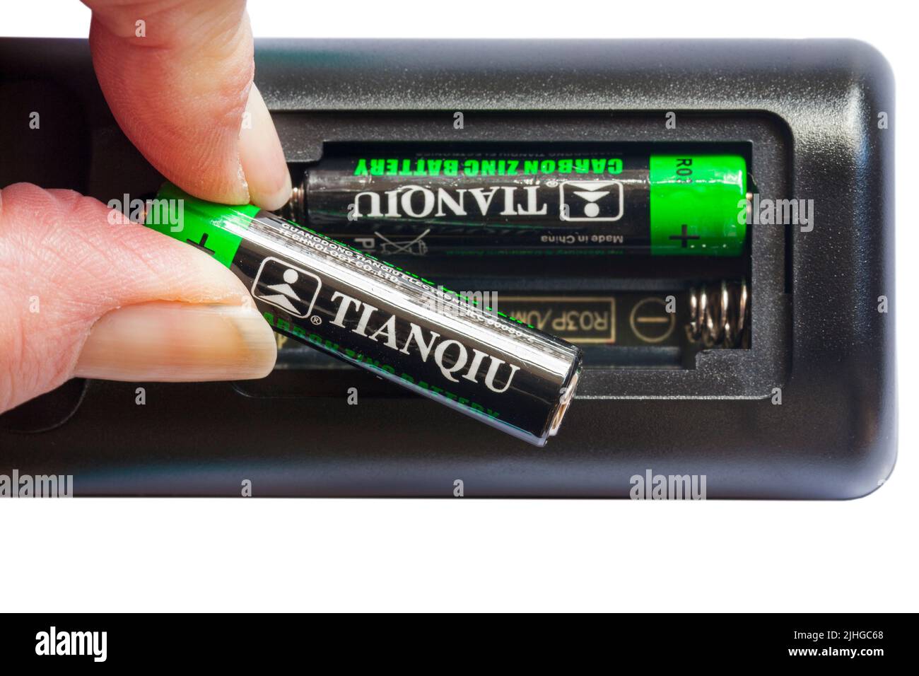 Tianqiu carbon zinc battery - woman changing batteries in remote ...
