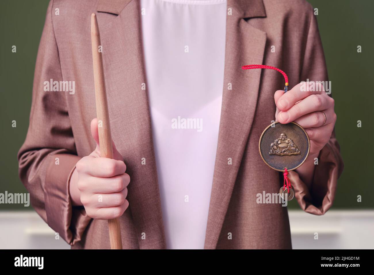 Woman teacher holding religious symbol with buddha on school blackboard ...