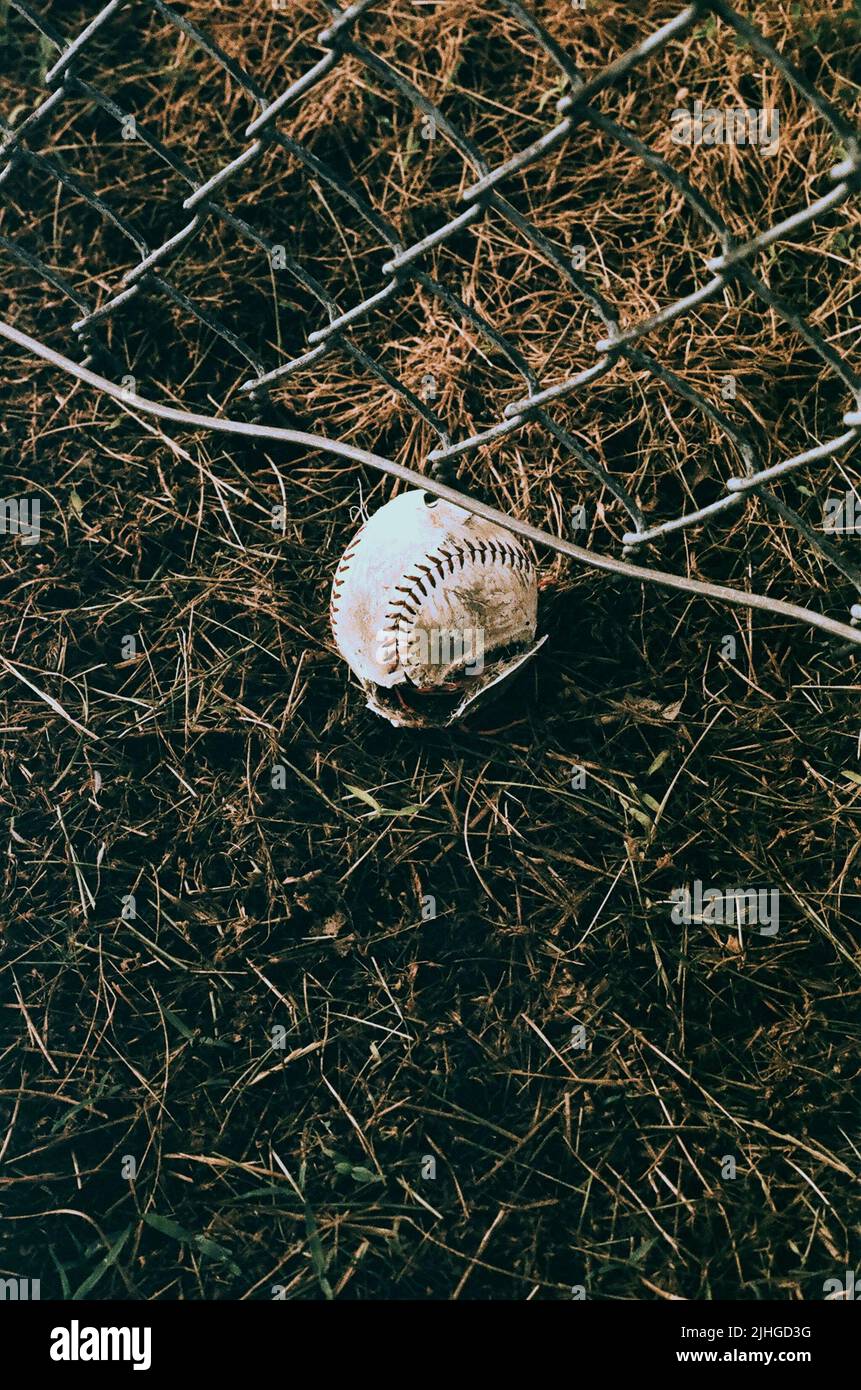 Torn Baseball Under Fence Stock Photo - Alamy