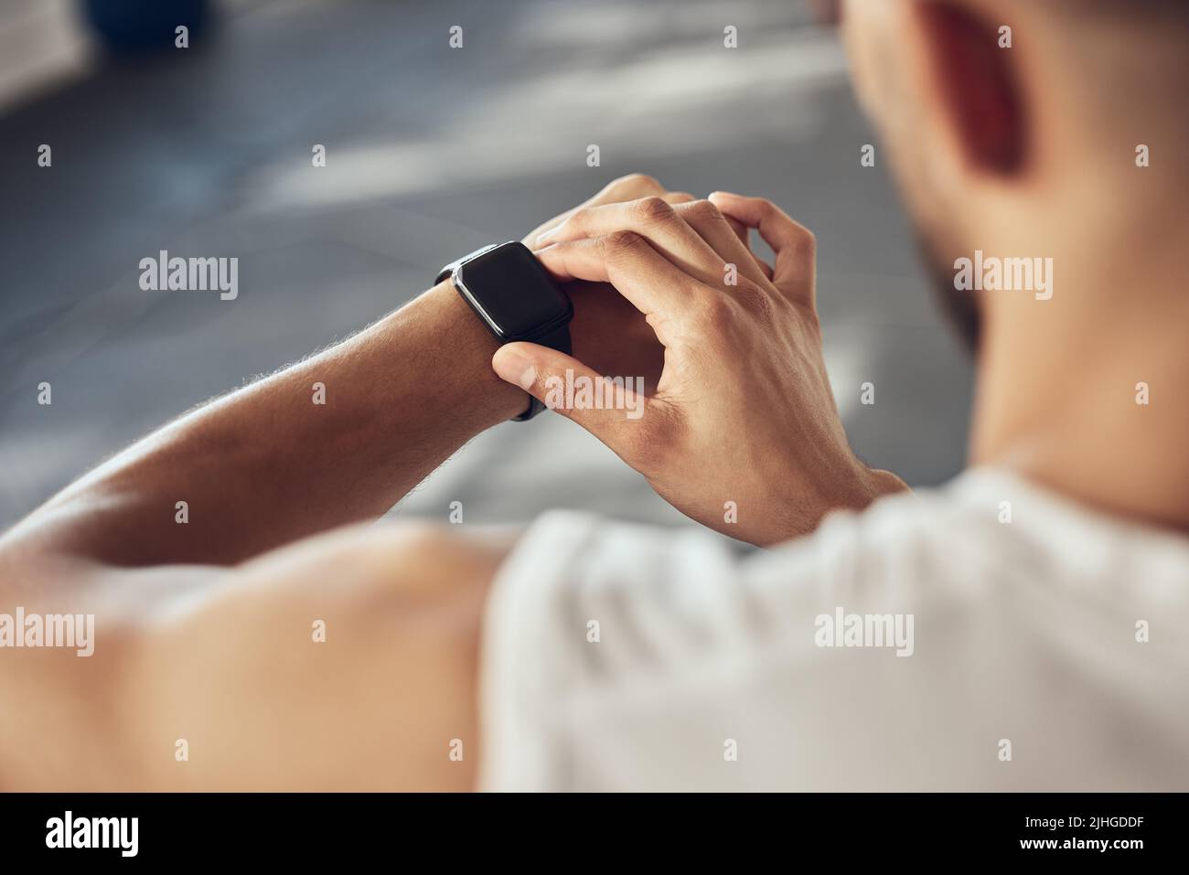 Fit athlete tracking his progress on his watch. Strong athlete using ...