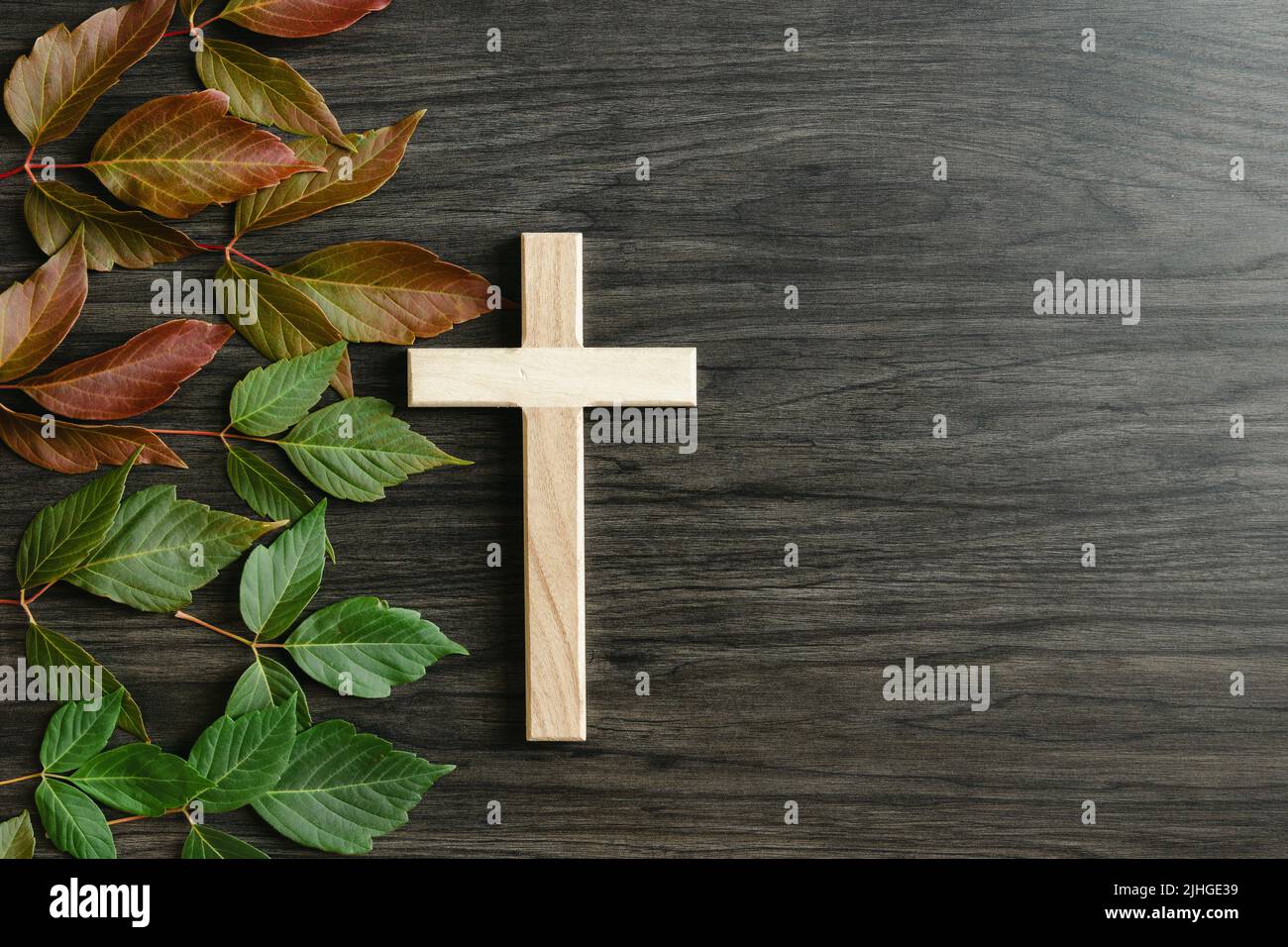 Small Christian cross on a dark wood background with a border of ...