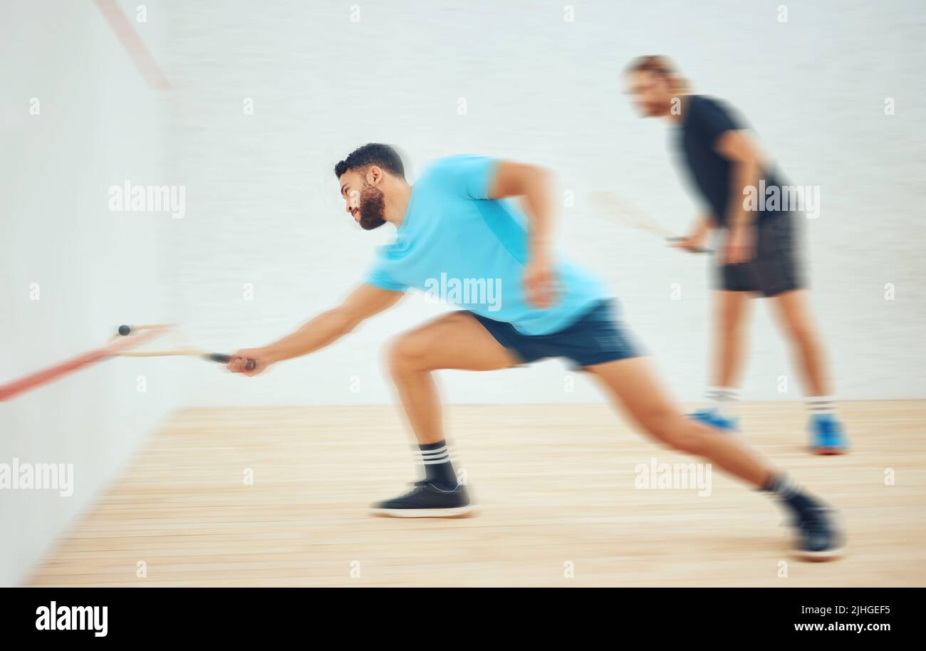 Two athletic squash players playing match during competitive court game ...