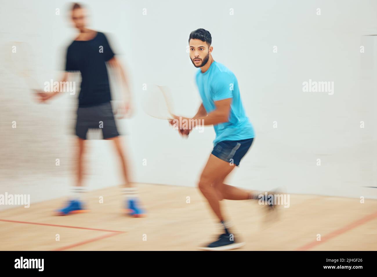 Two athletic squash players playing a game on a court with copyspace ...