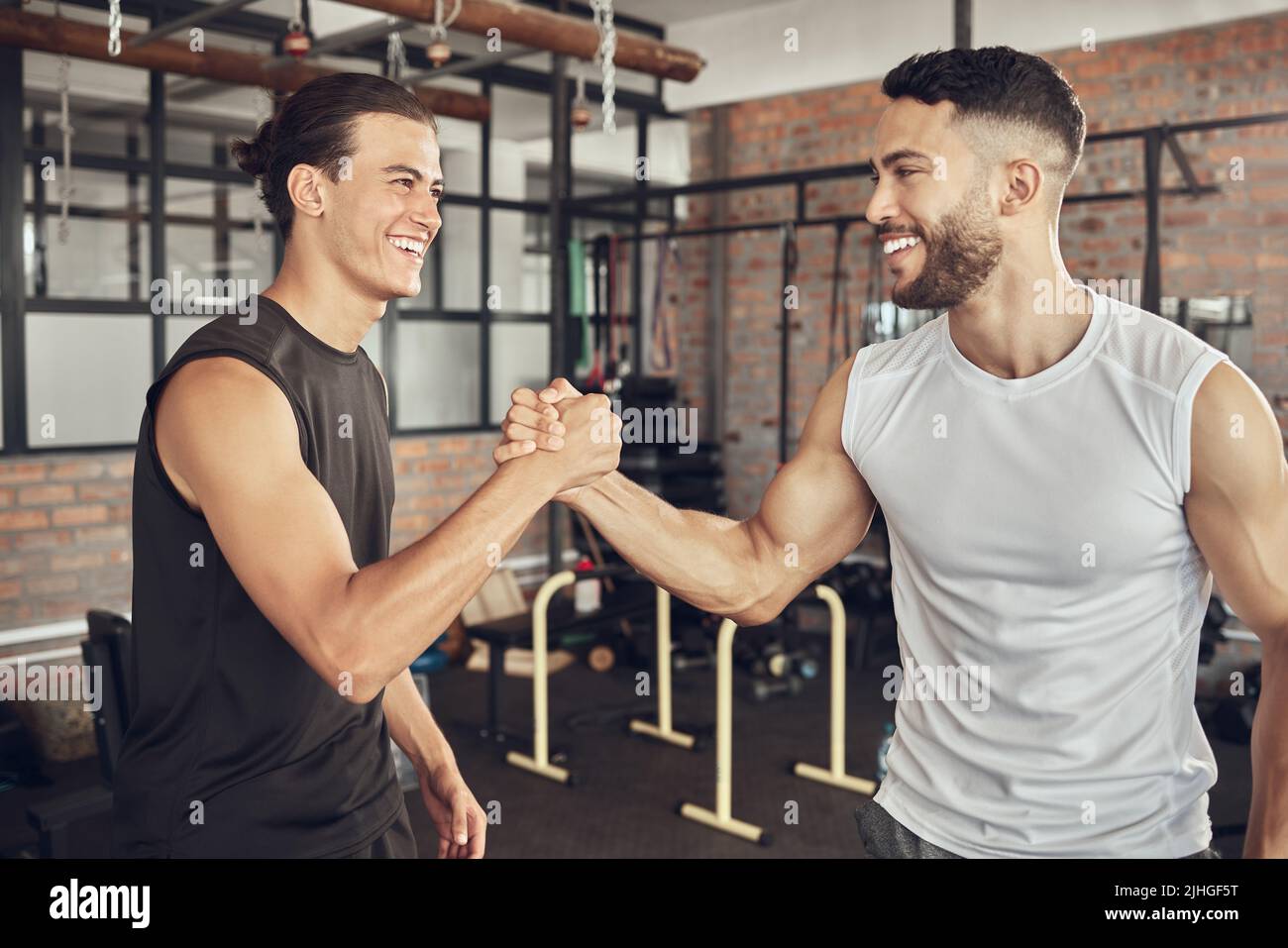 Cheerful athletes greeting each other. Fit bodybuilders collaborate on ...