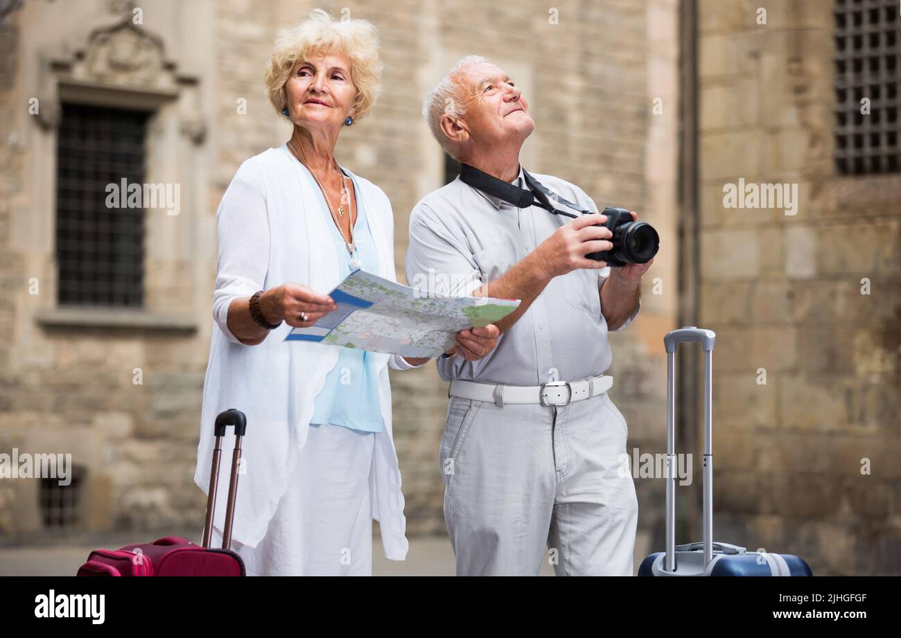 Senior woman and man traveling together looking for destination with ...