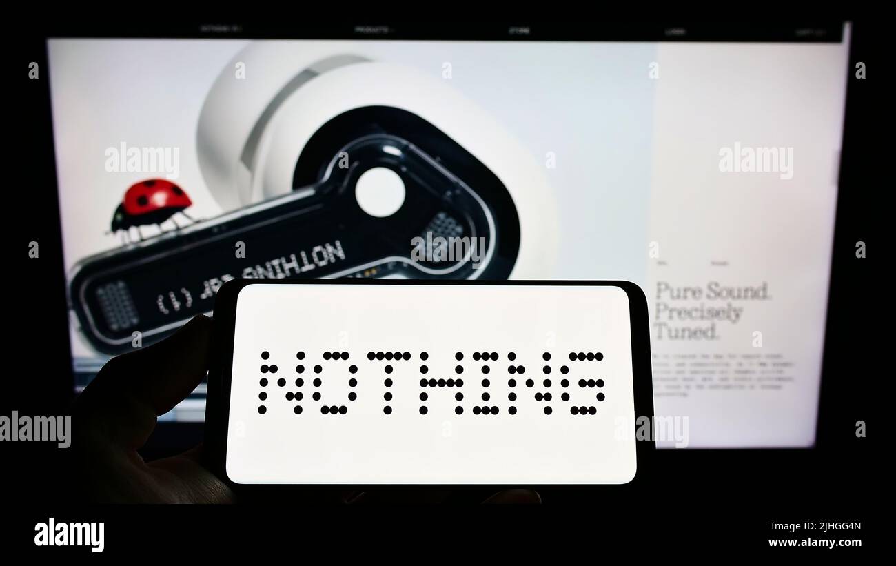 Person holding mobile phone with logo of British company Nothing Technologies Limited on screen ...
