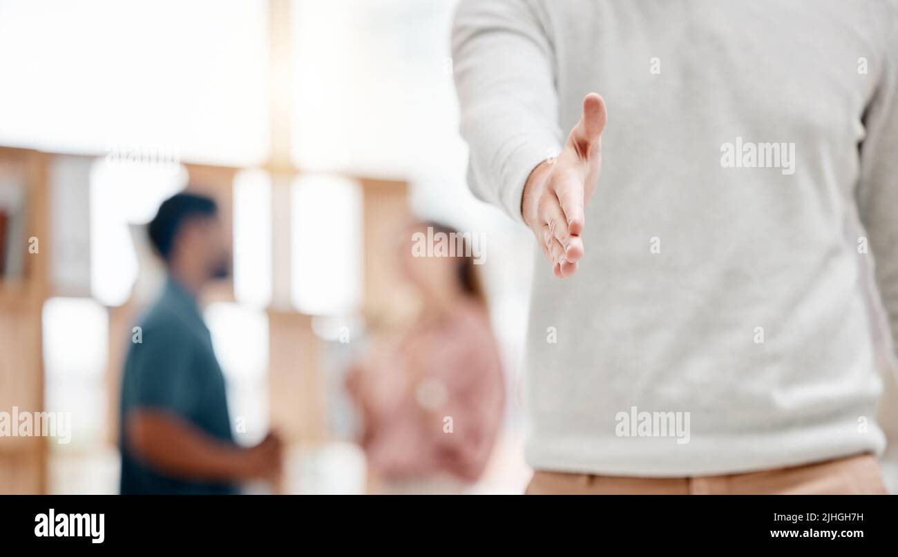 Businessperson extending their hand for a handshake in an office alone ...