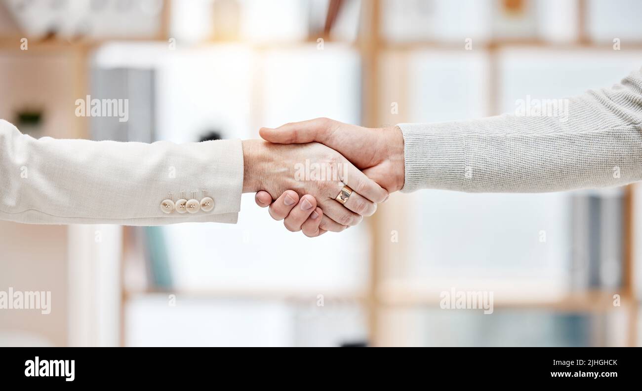 Two businesspeople shaking hands in a meeting at work. Business ...