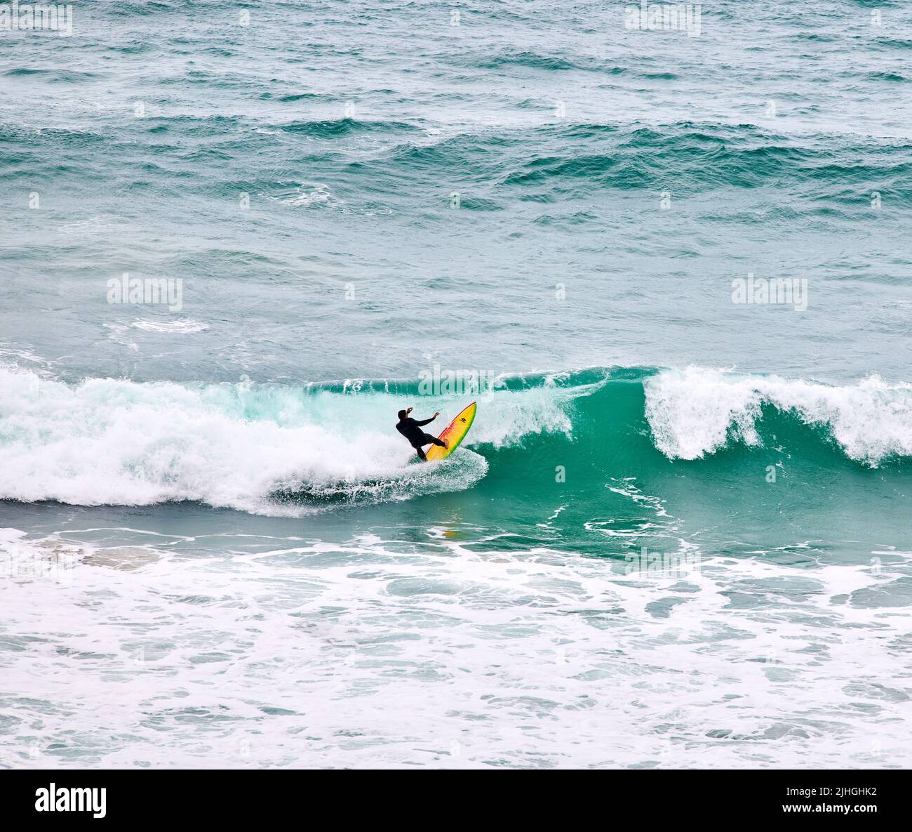 A surfer climbs a surf wave of the Atlantic ocean off the Great Western ...