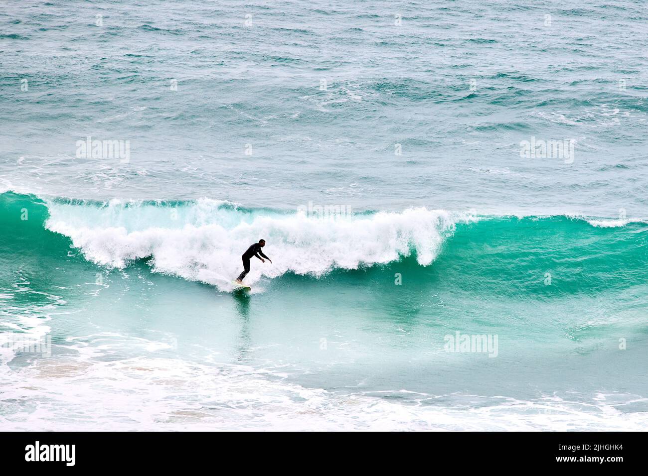A surfer rides a surf wave of the Atlantic ocean off the Great Western ...