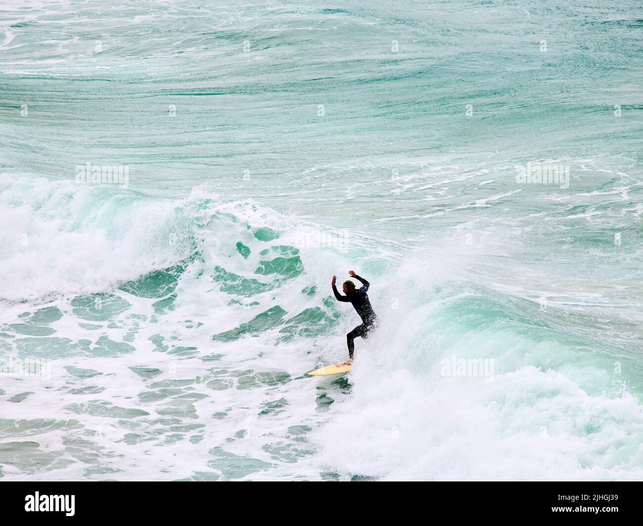 A surfer rides a surf wave of the Atlantic ocean off the Great Western ...