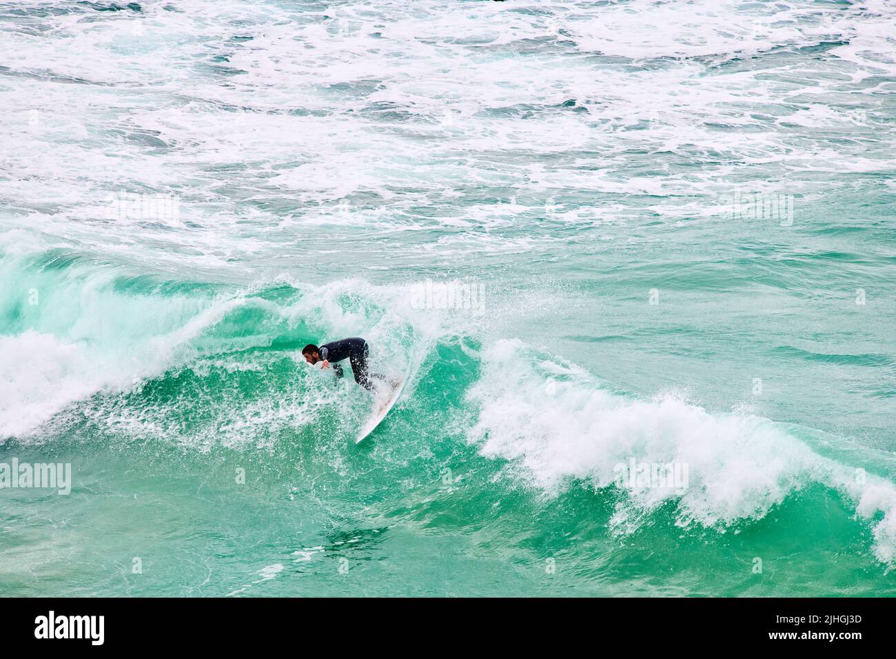 A surfer descends a surf wave of the Atlantic ocean off the Great ...