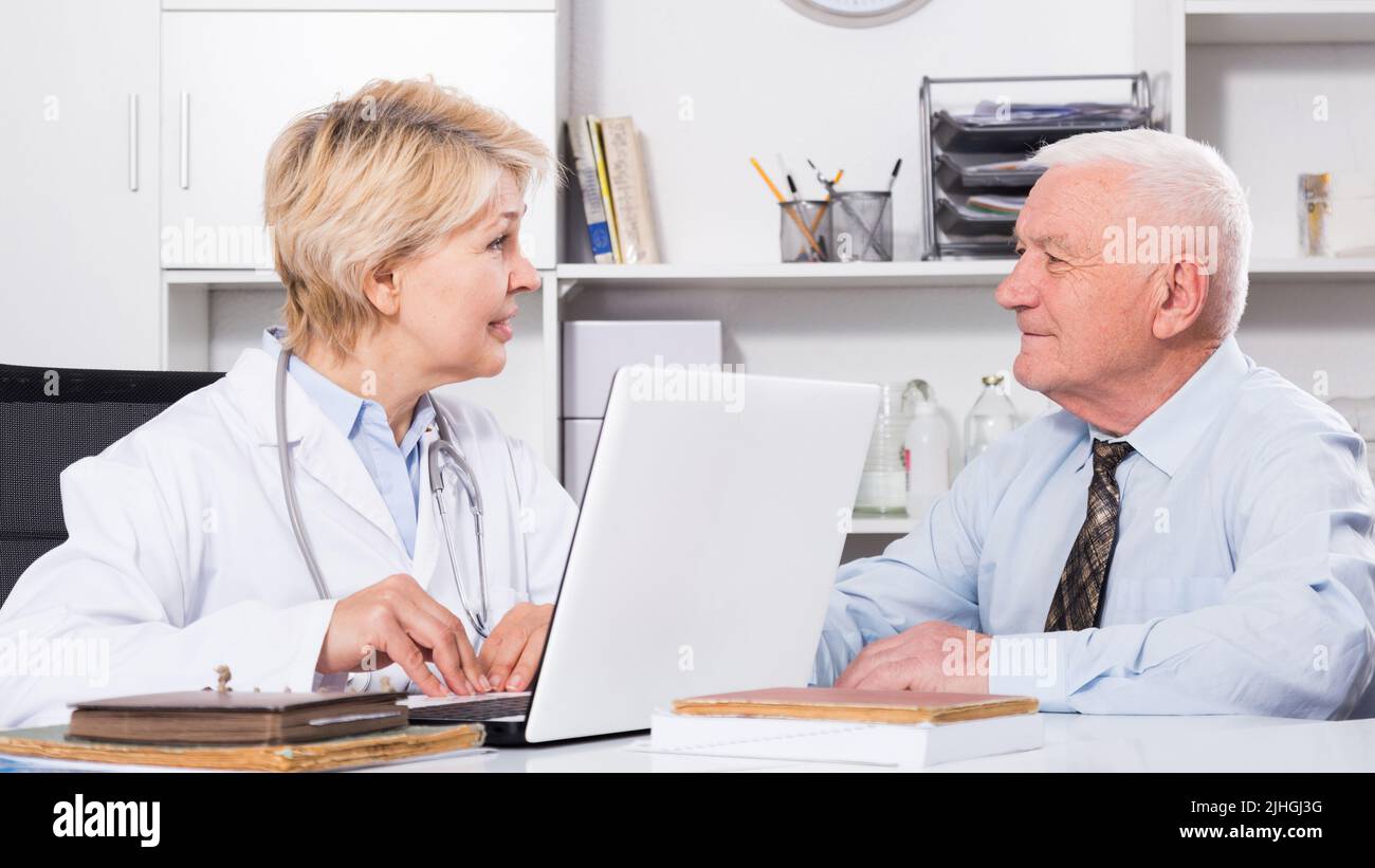 Female doctor with male client Stock Photo - Alamy