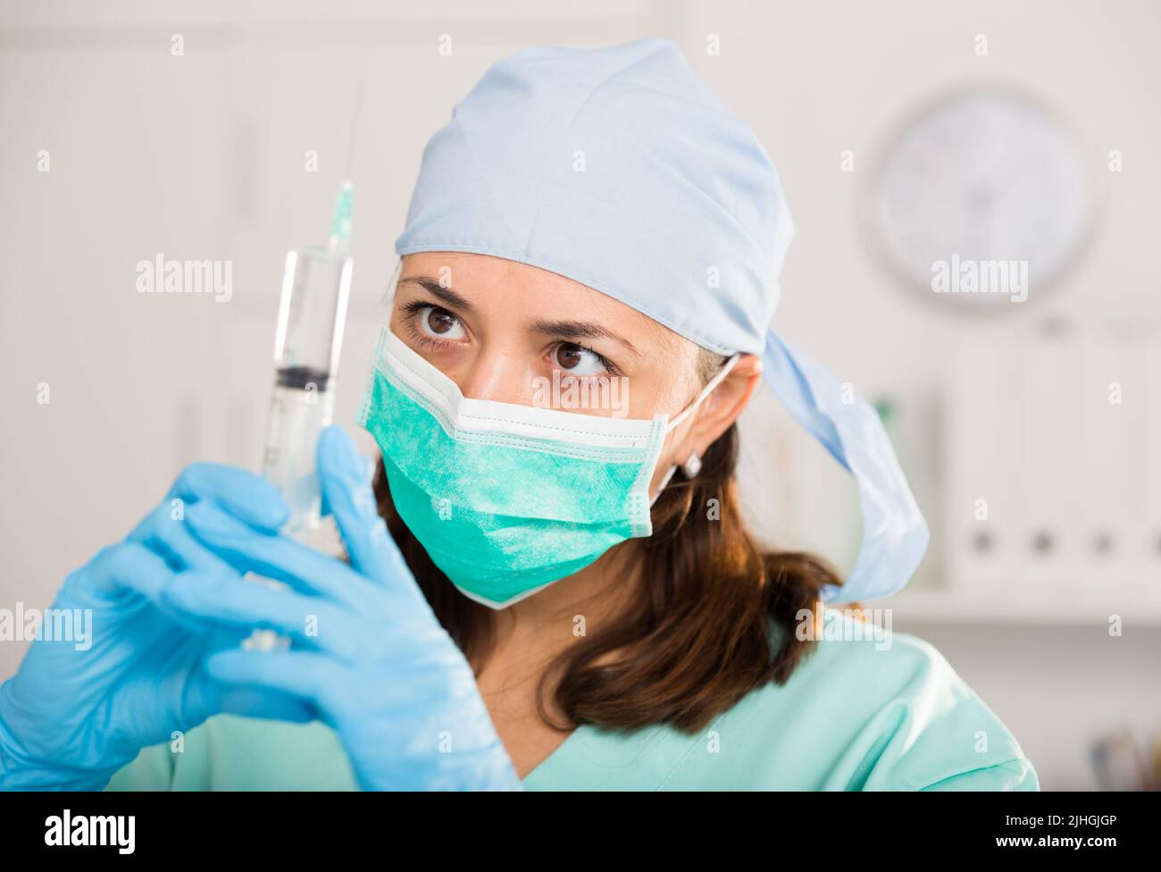 Female nurse in mask holding syringe for injection in hospital Stock ...