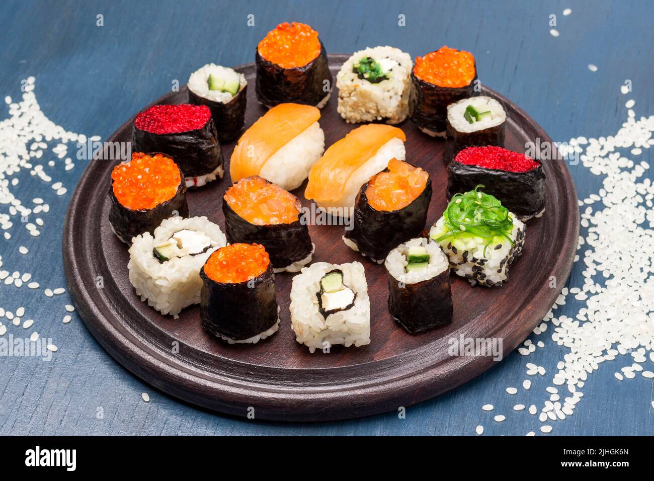 Sushi set on cutting board. Rice on the table. Top view. Blue ...