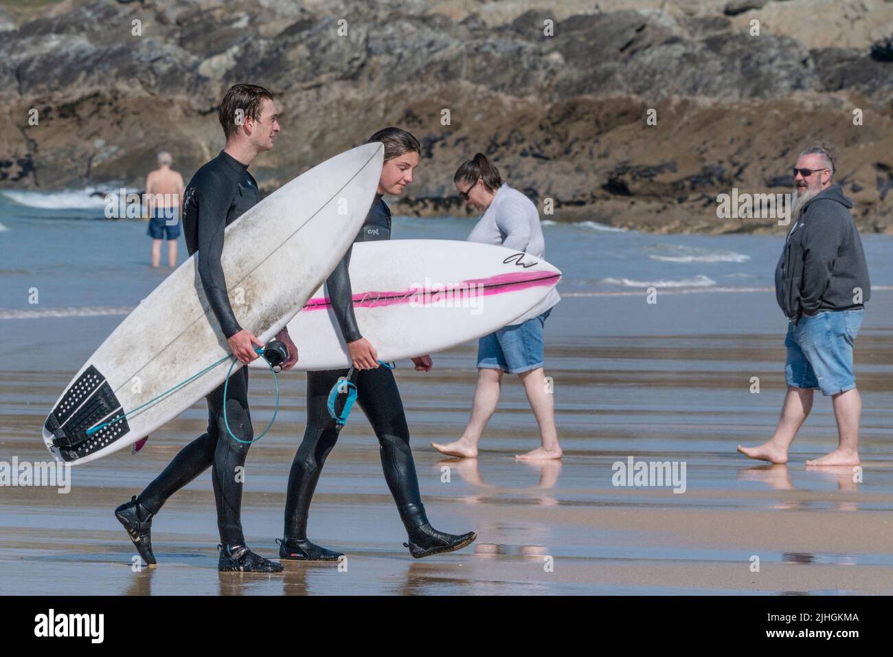Surfers carrying their surfboards and walking at the end of a surfing ...