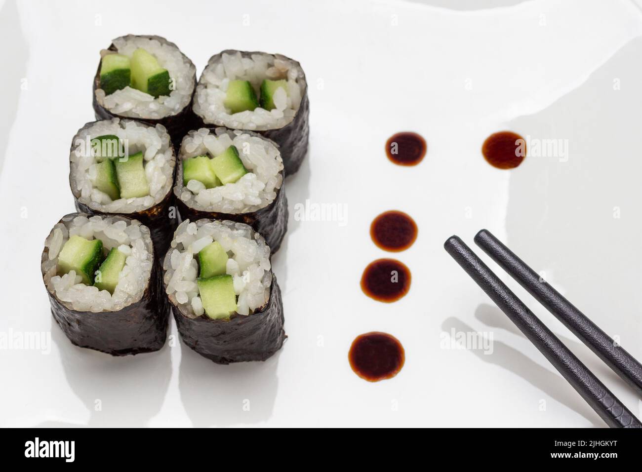 Nori maki and black chopsticks. White background. Flat lay Stock Photo - Alamy