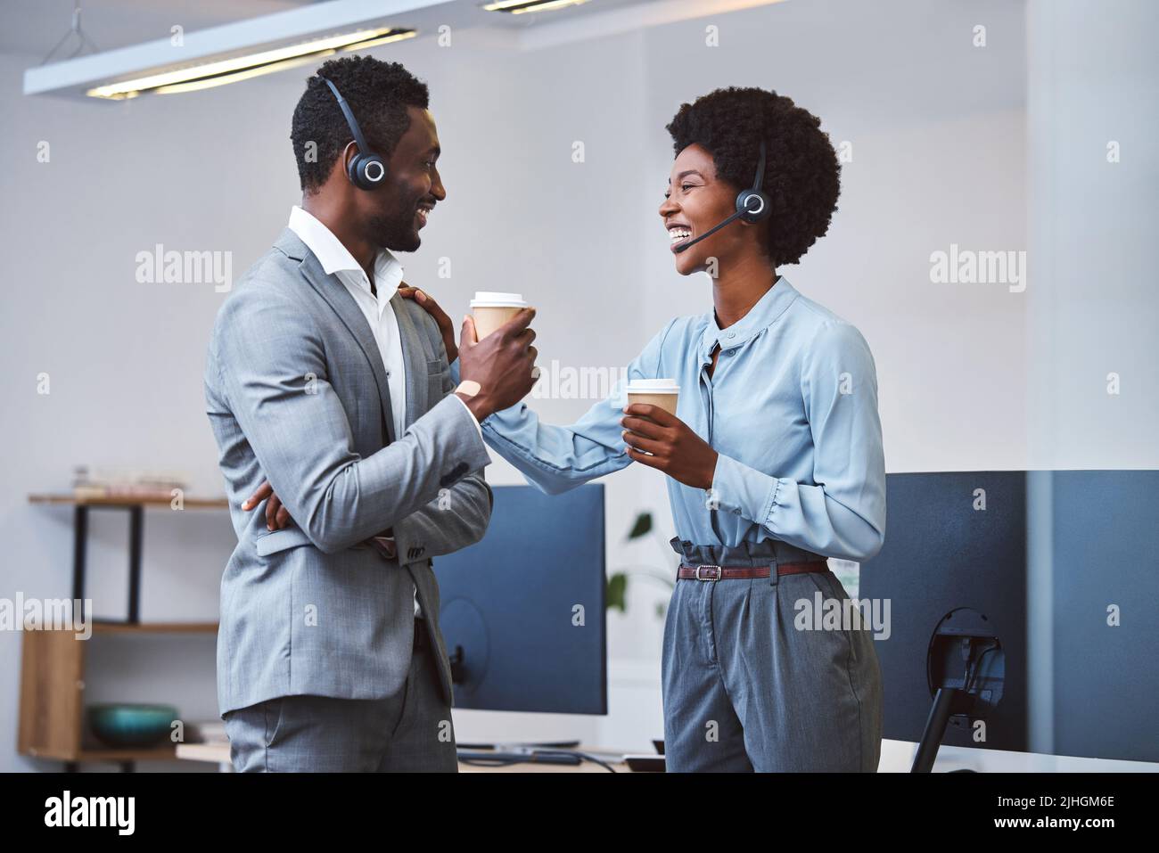 Two happy young african american call centre telemarketing agents ...