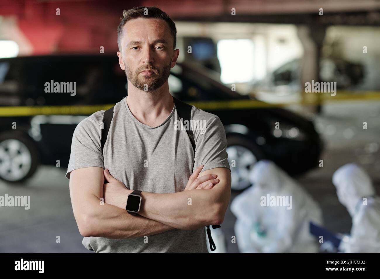 Young serious crime scene worker or detective inspector looking at ...