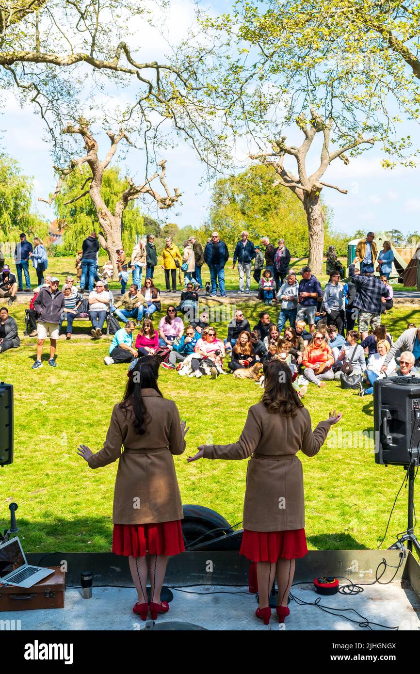 Two women singers on a small stage singing vintage songs to a mainly ...