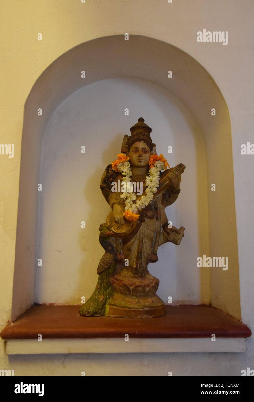 sculpture of god with flower garland Stock Photo - Alamy