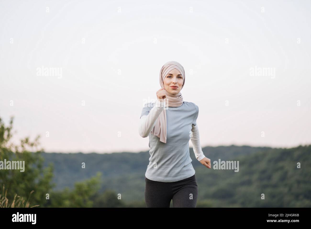 Jogging Arabic woman in hijab running in green park on beautiful summer ...