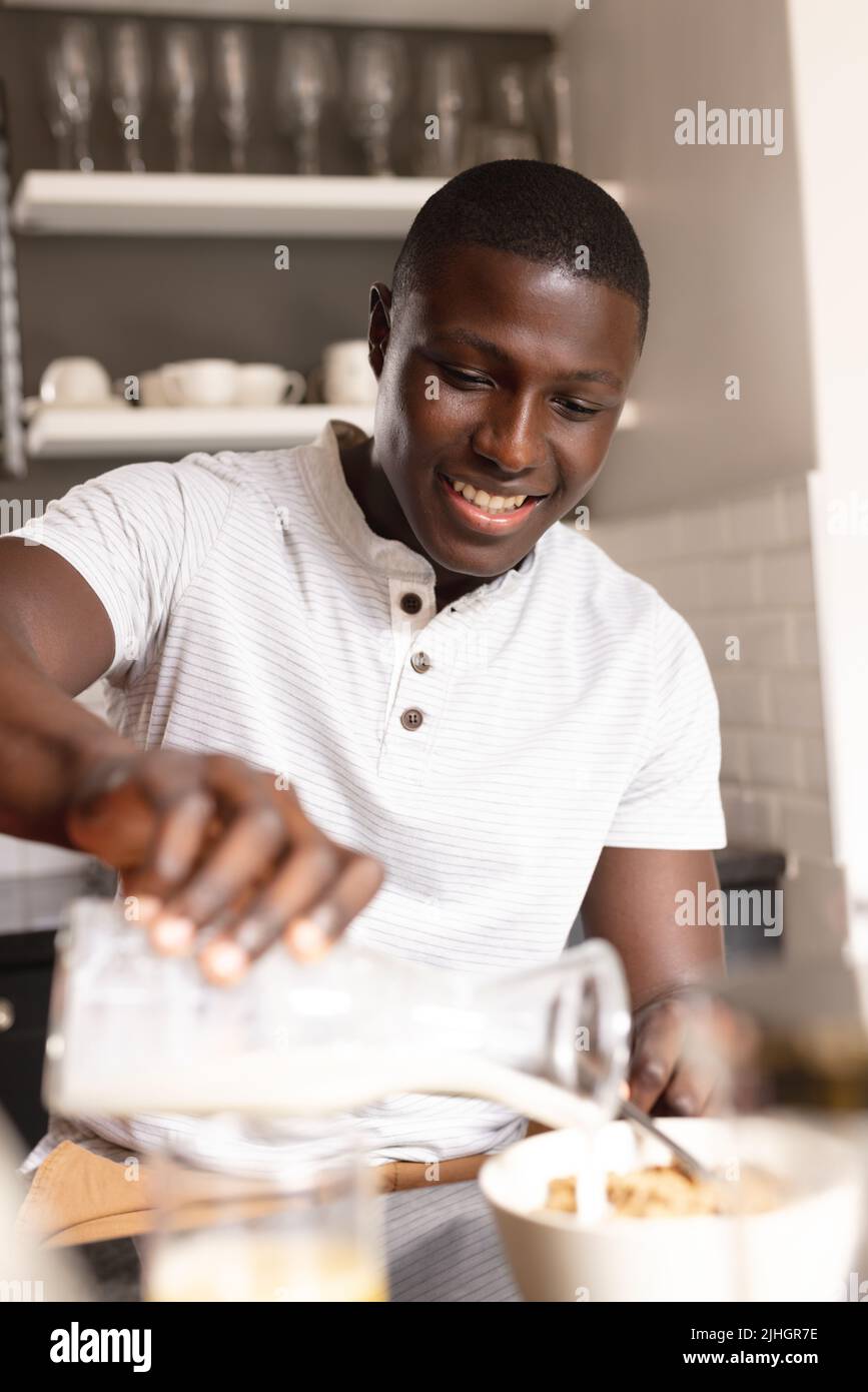 Vertical image of happy african american man cooking Stock Photo - Alamy