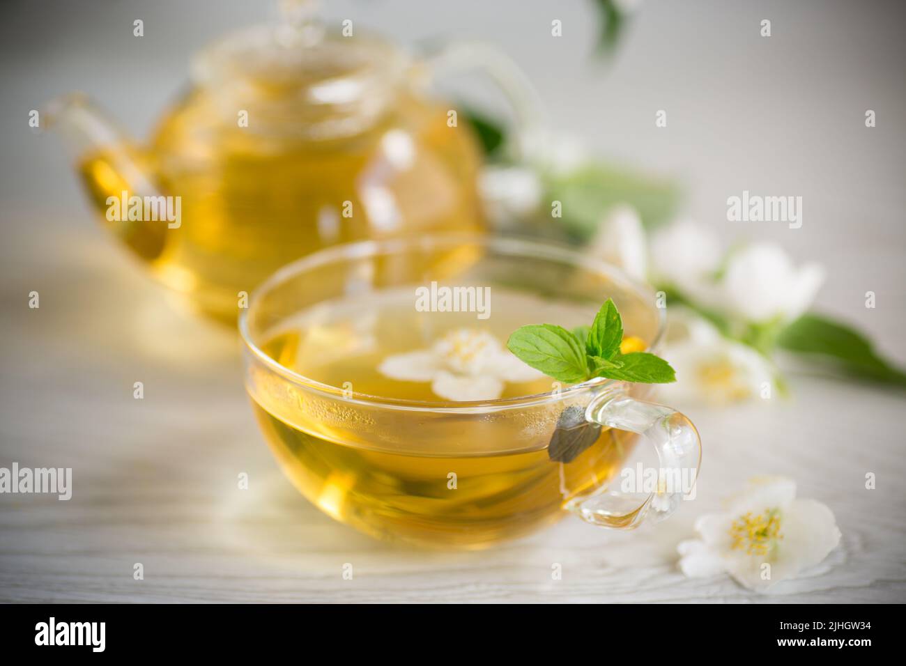 Composition with cup of jasmine tea and flowers on light background ...