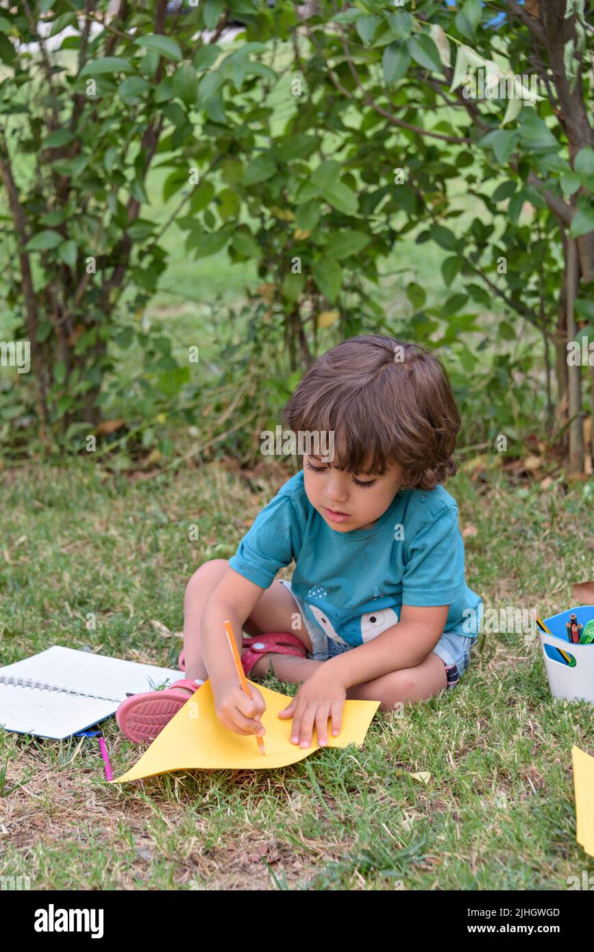Little boy are using a magic pen to draw pictures in a book on a wooden ...