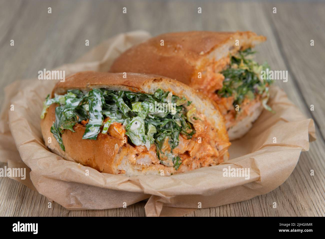 Spicy buffalo chicken sandwich loaded with meat, lettuce, and mayo on ...
