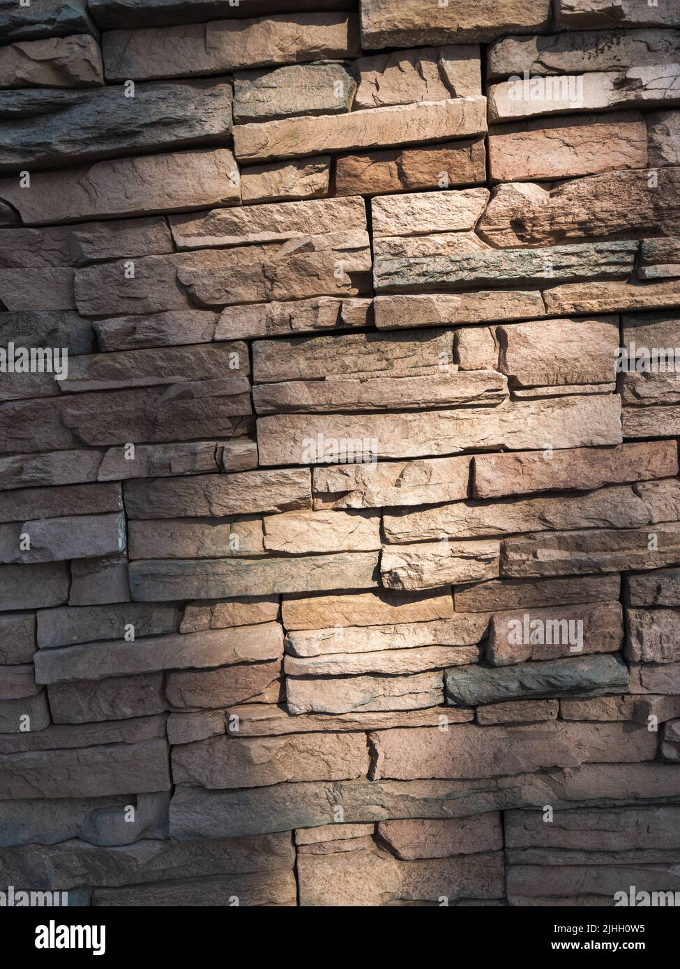 Mottled afternoon sunlight on stacked narrow fieldstone wall Stock ...
