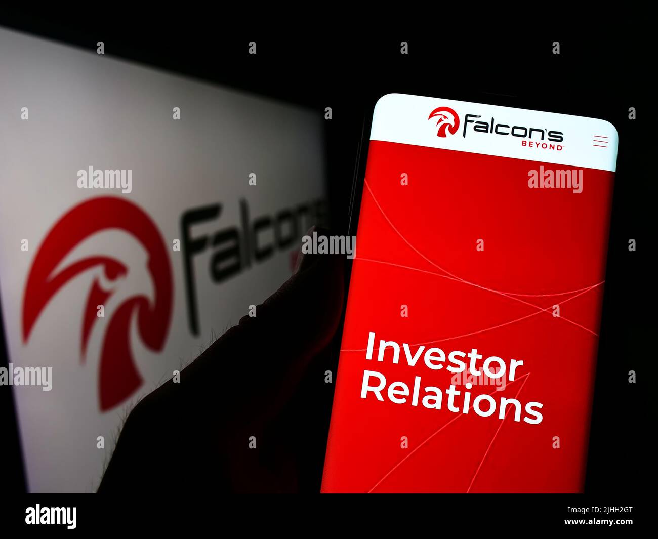 Person holding cellphone with webpage of entertainment company Falcon's Beyond Global LLC on ...