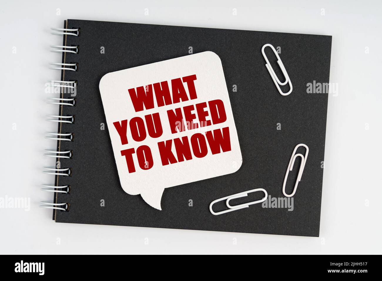 Business concept. On the notebook are white paper clips and a sign with ...