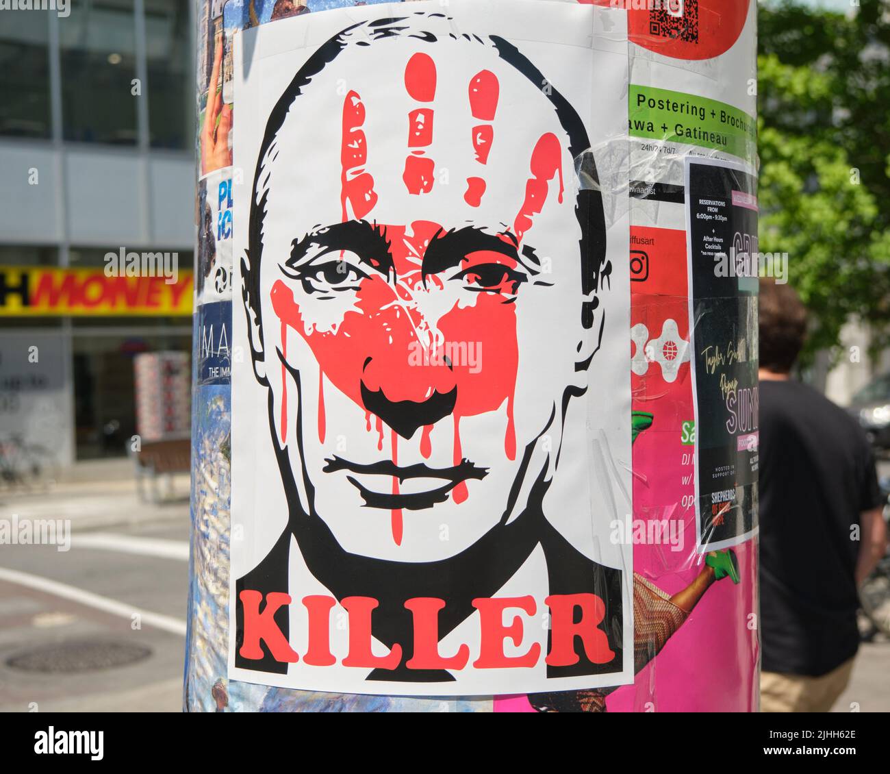 Poster with the face of Putin with blood red hand and calling him a ...