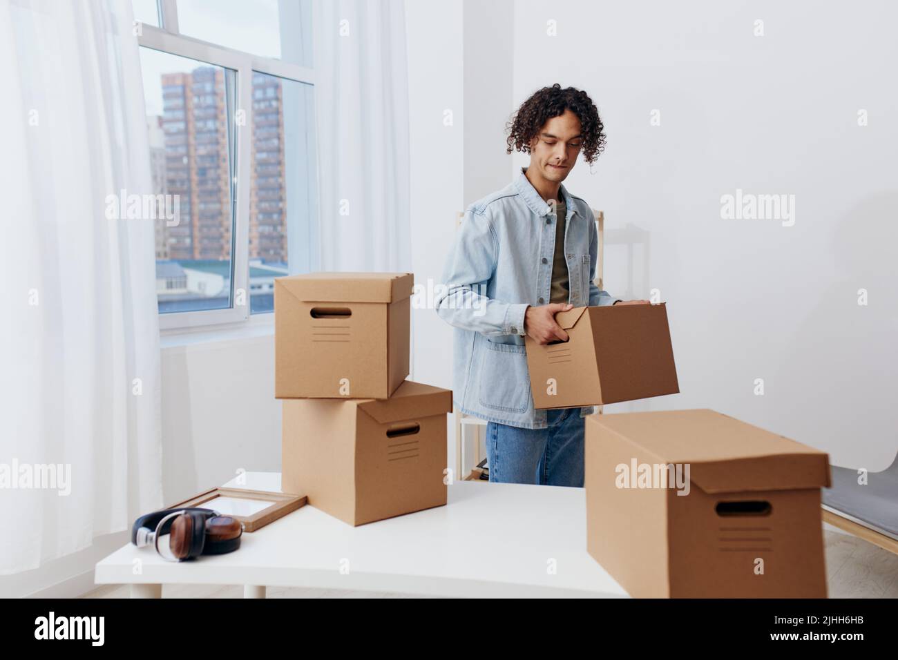 portrait of a man unpacking things from boxes in the room Lifestyle ...