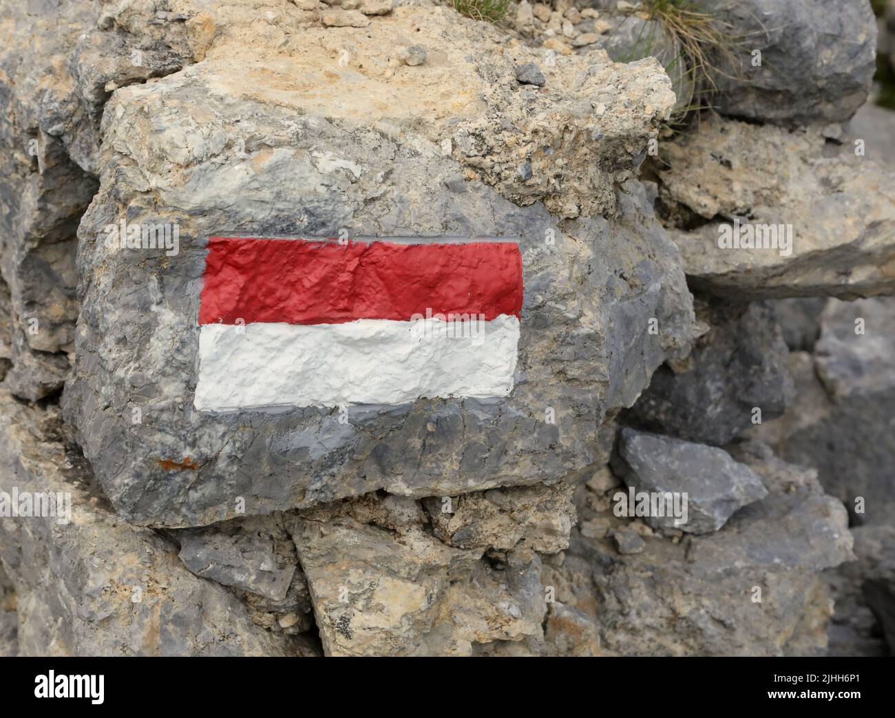 red and white stripes to mark the trail in the mountains on a rock ...