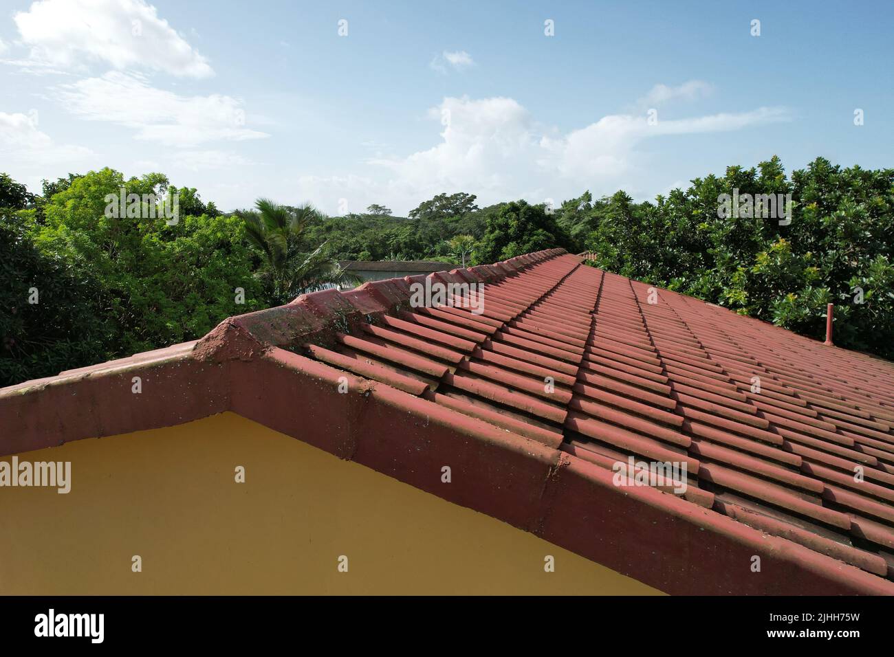 Red home roof with clay tiles on blue sky background Stock Photo - Alamy
