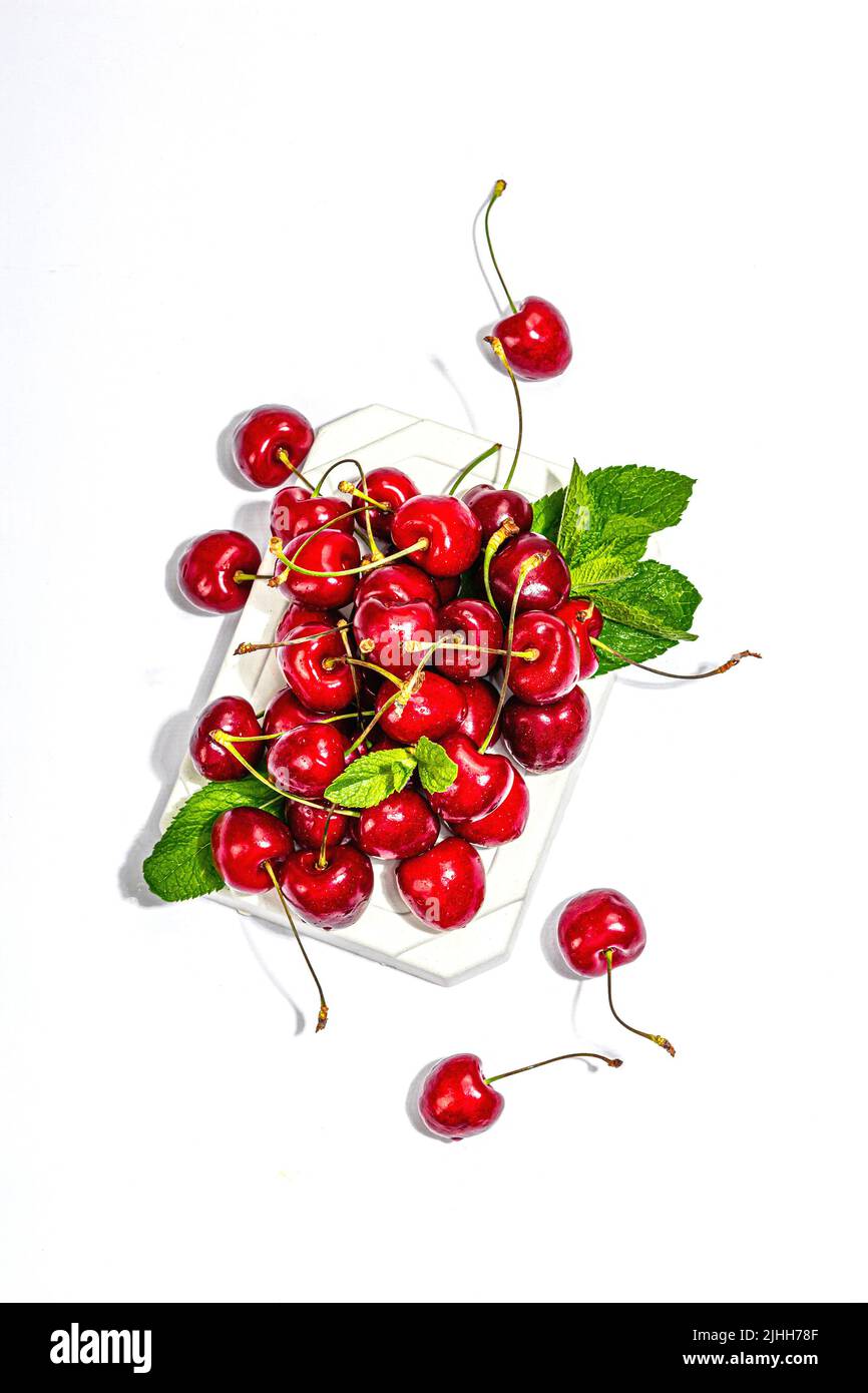 Ripe sweet cherries with fresh mint leaves isolated on white background ...