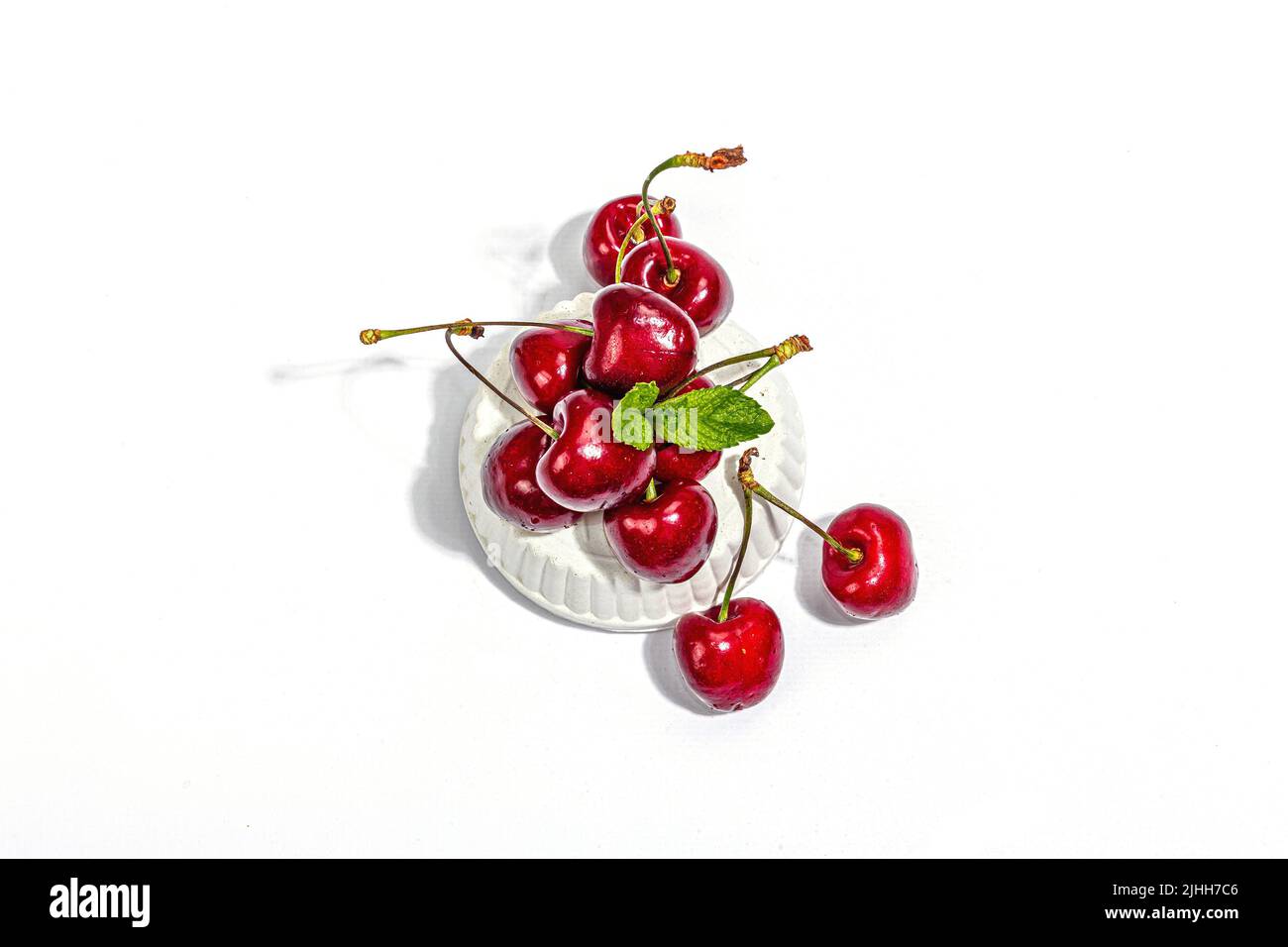 Ripe sweet cherries with fresh mint leaves isolated on white background ...