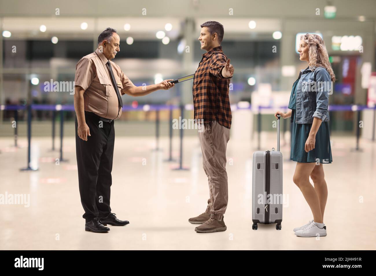 Security guard checking passengers with a scanner on an airport Stock ...