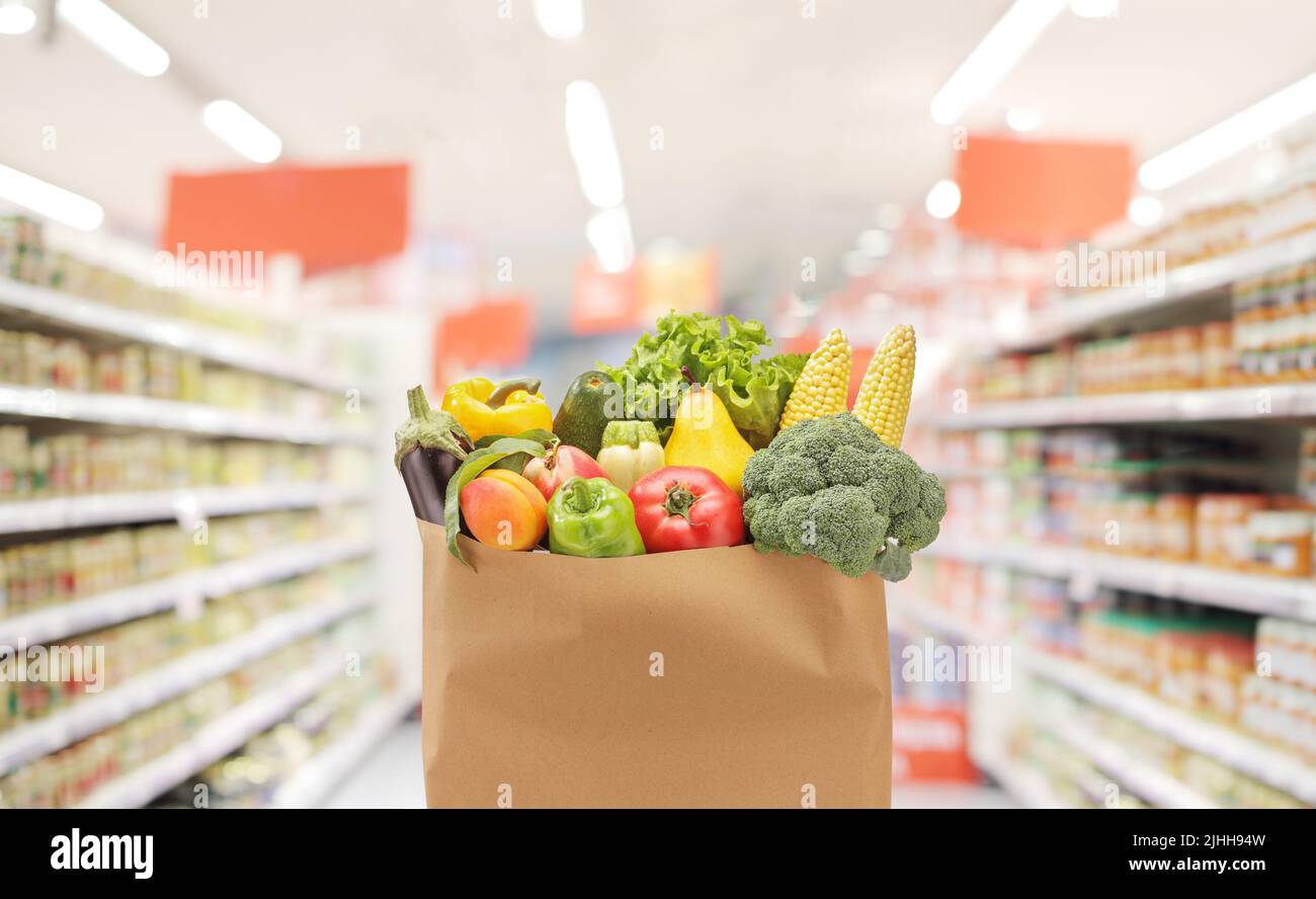 Fresh fruits and vegetables in a paper bag in a supermarket Stock Photo ...