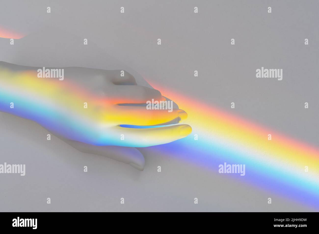 Top view of the white plastic toy hand with rainbow flag like symbol ...