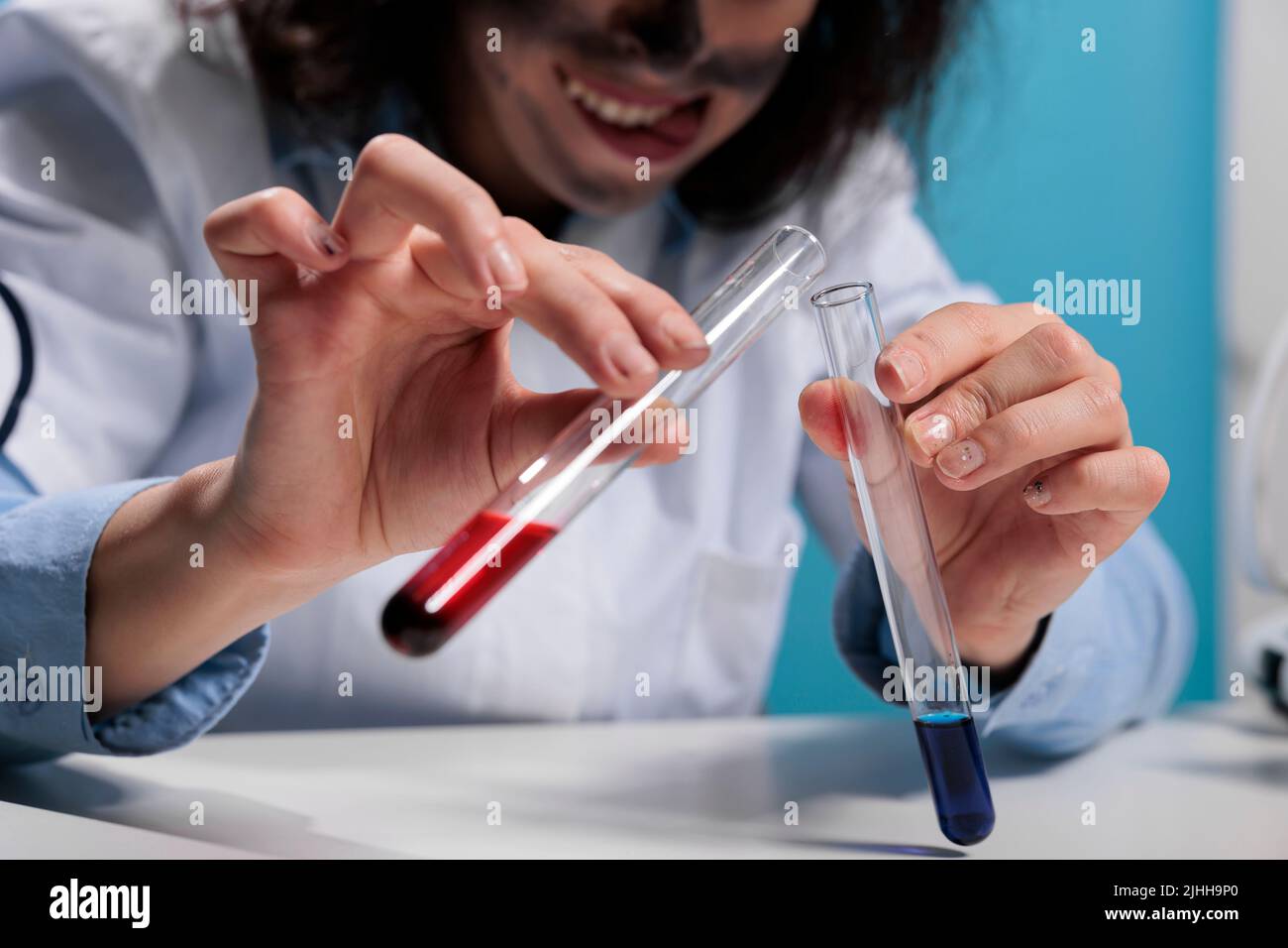 Close up of mad scientist hands mixing experimental liquid chemical ...