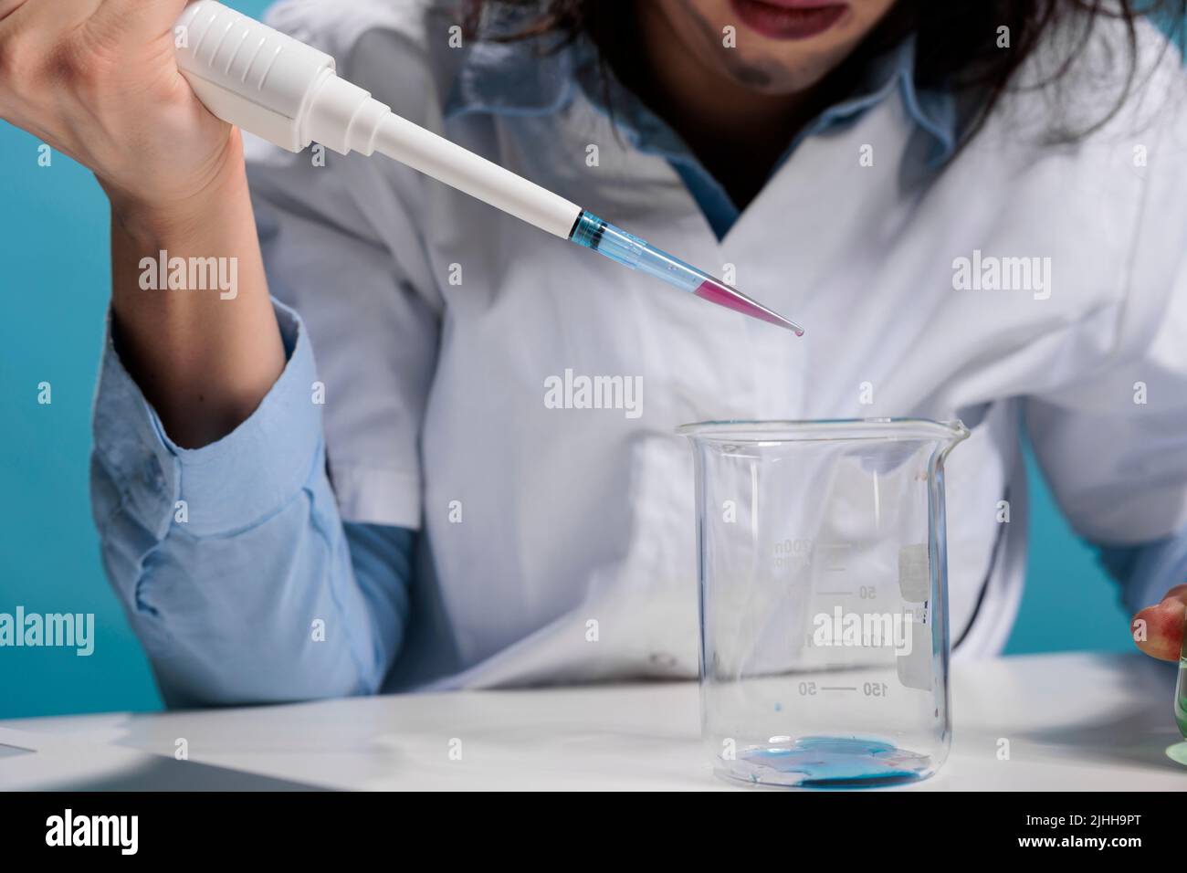 Close up portrait of wacky insane chemist using dropper to mix ...