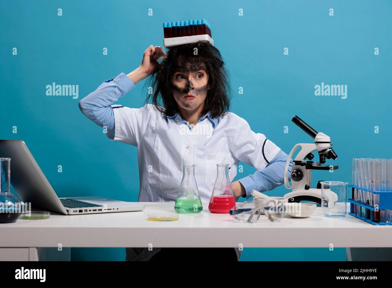 Portrait of funny looking crazy chemist acting silly while having tray ...