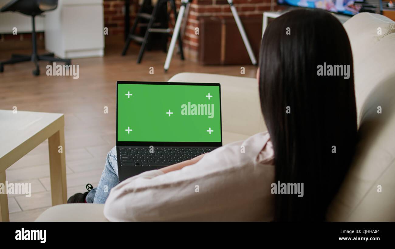 Woman sitting on couch inside apartment with portable computer having ...