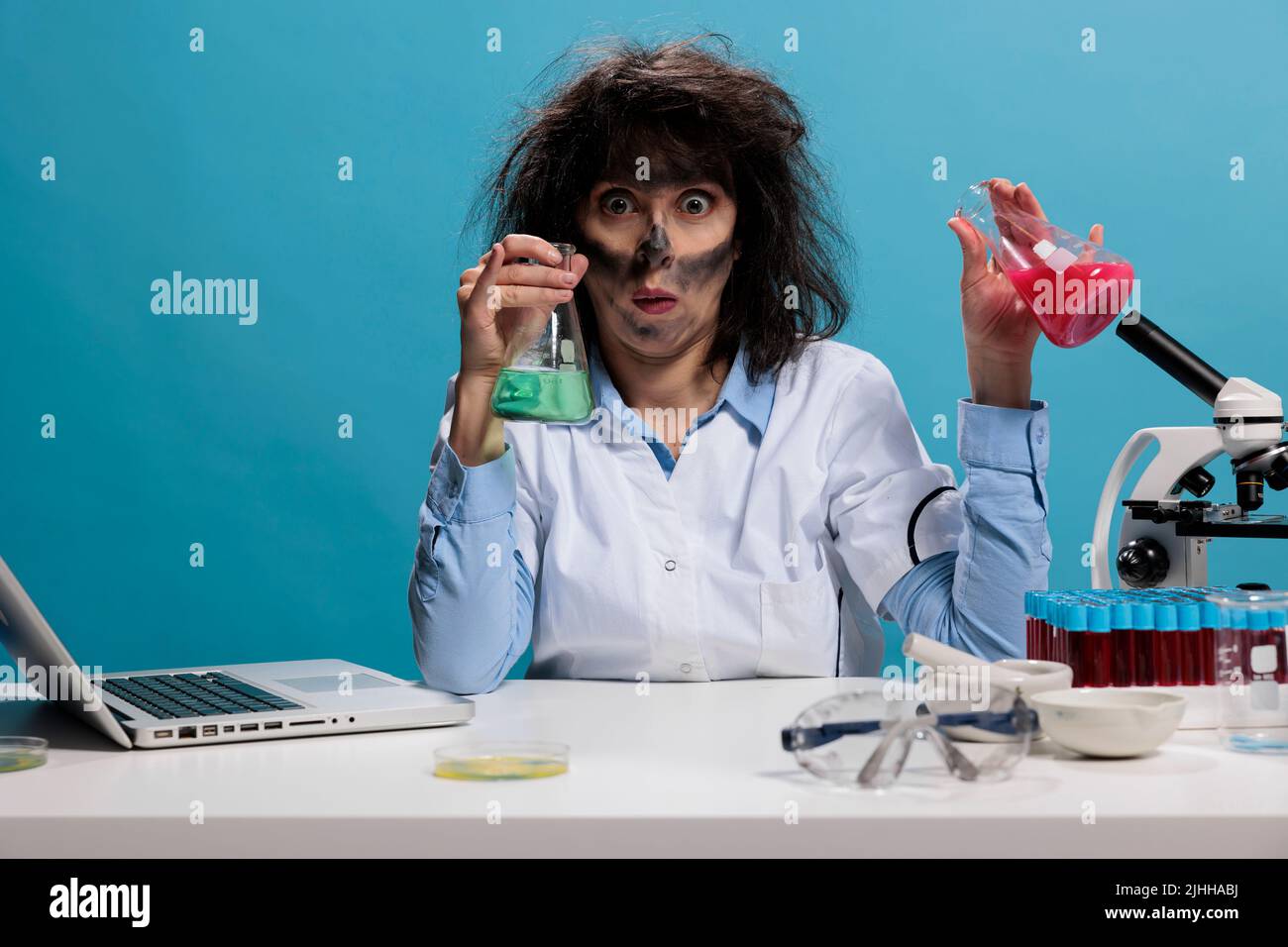 Mad silly looking crazy lab worker sitting at desk while having glass ...