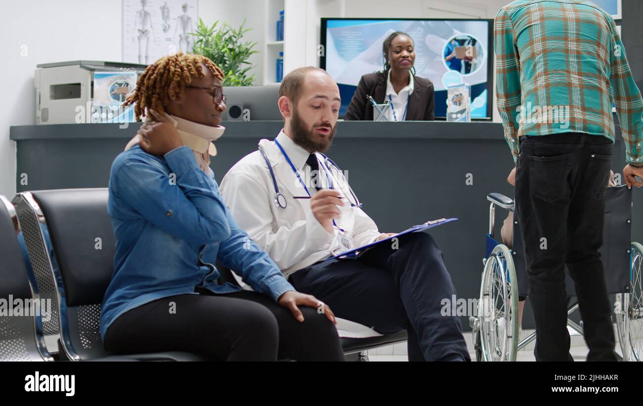 African american woman with cervical collar being hurt in pain, talking ...