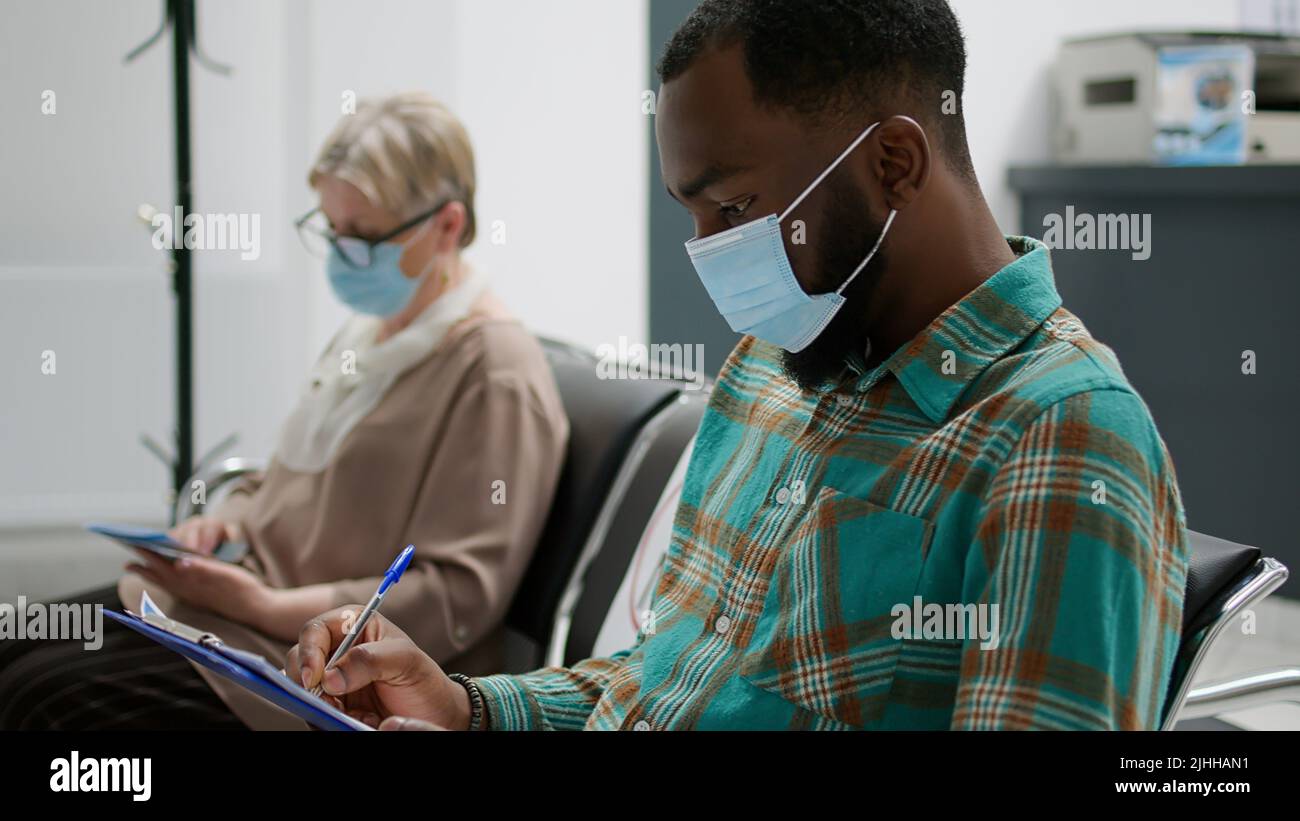 Diverse group of people with face masks in waiting area during covid 19 ...