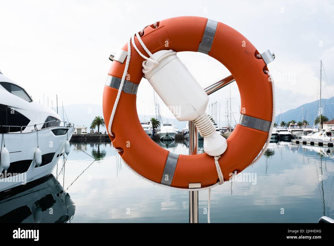 Orange lifebuoy on the background of marina. Rescue buoy hanging on ...